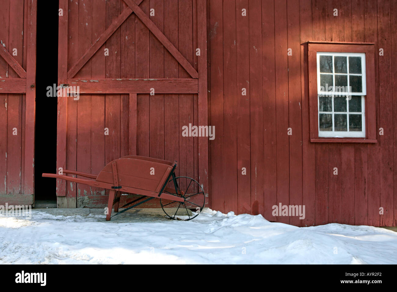 An old red wheelbarrow in front of a red barn Stock Photo - Alamy