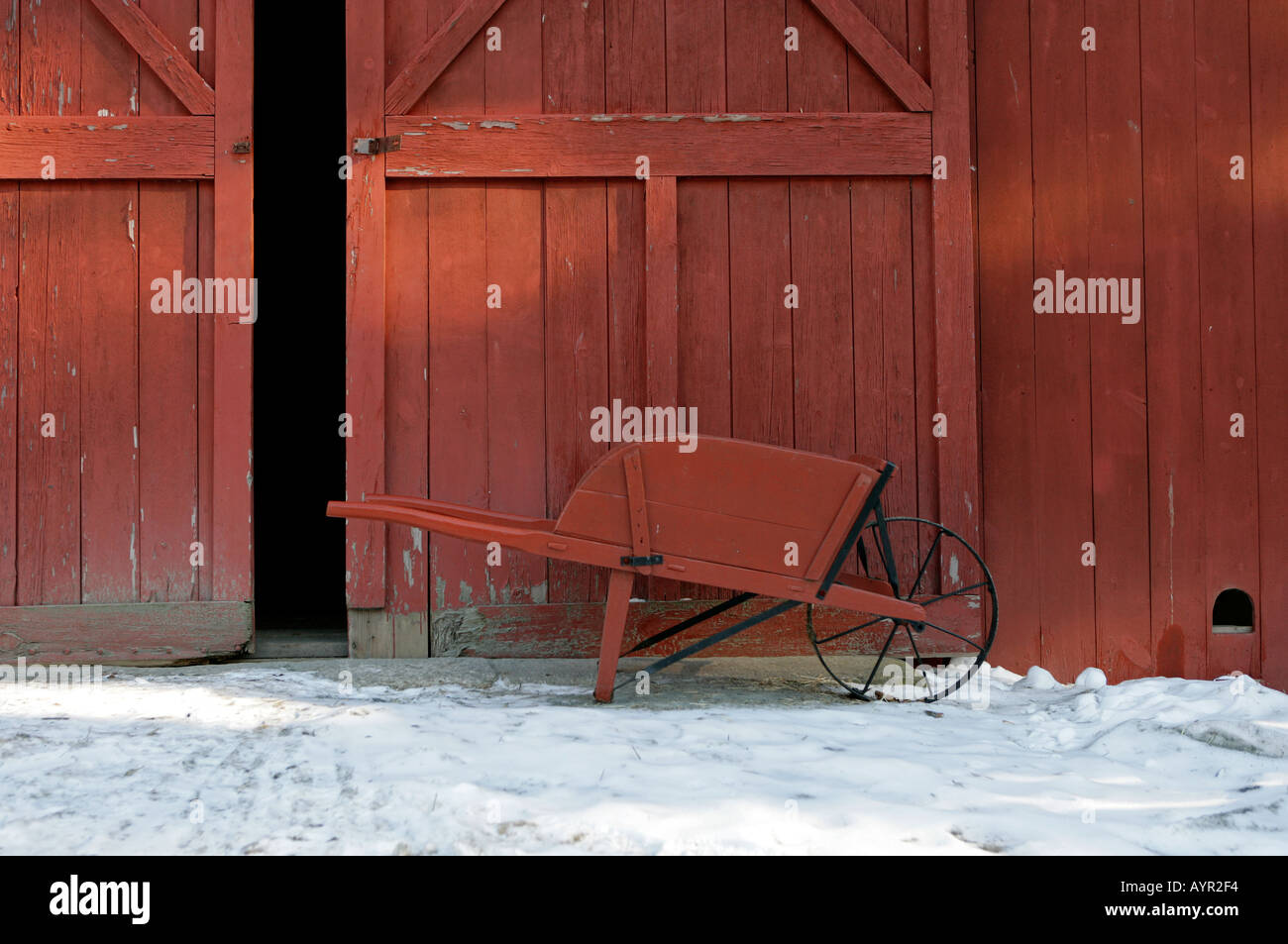 An old red wheelbarrow in front of a red barn Stock Photo - Alamy