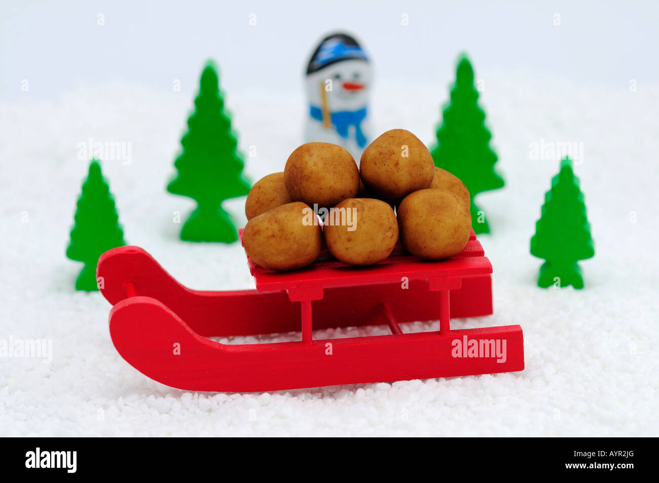 Marzipan potatoes on a red sleigh, snowy scene Stock Photo - Alamy