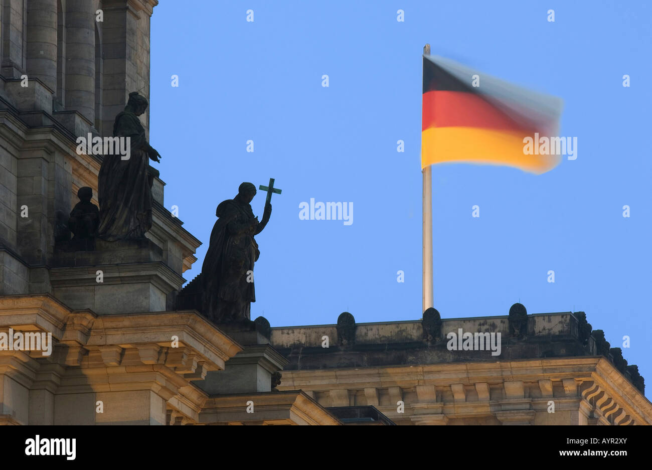 German flag waving on the roof of the Reichstag and a statue holding a ...