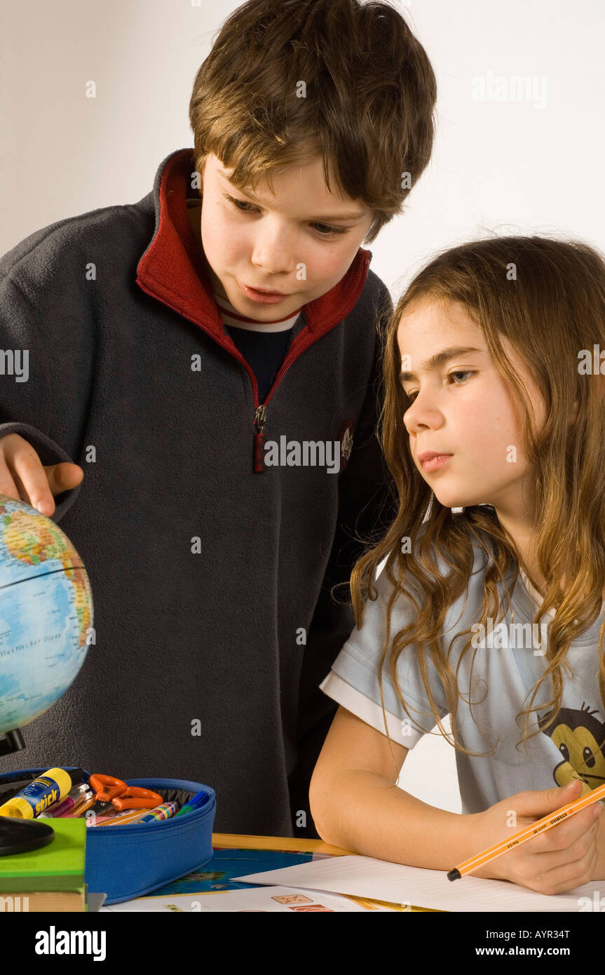 Siblings, ten-year-old boy and his nine-year-old sister doing homework ...