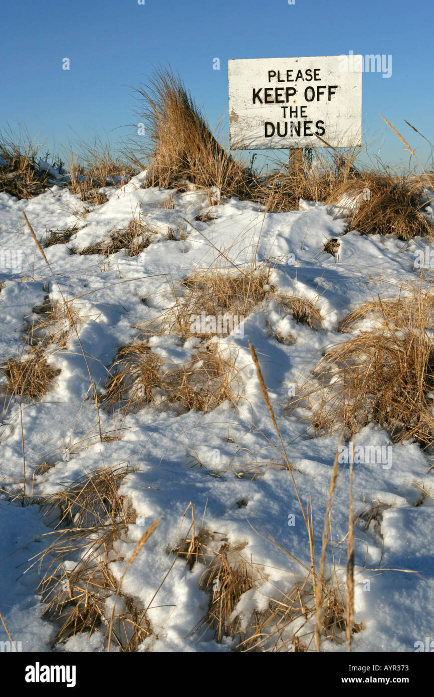 A Please Keep Off The Dunes sign on a dune in winter with snow Stock ...