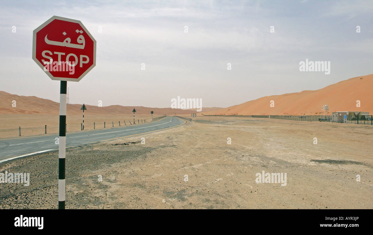 Arabic and English stop sign on a desert road junction near Moreeb Dune ...