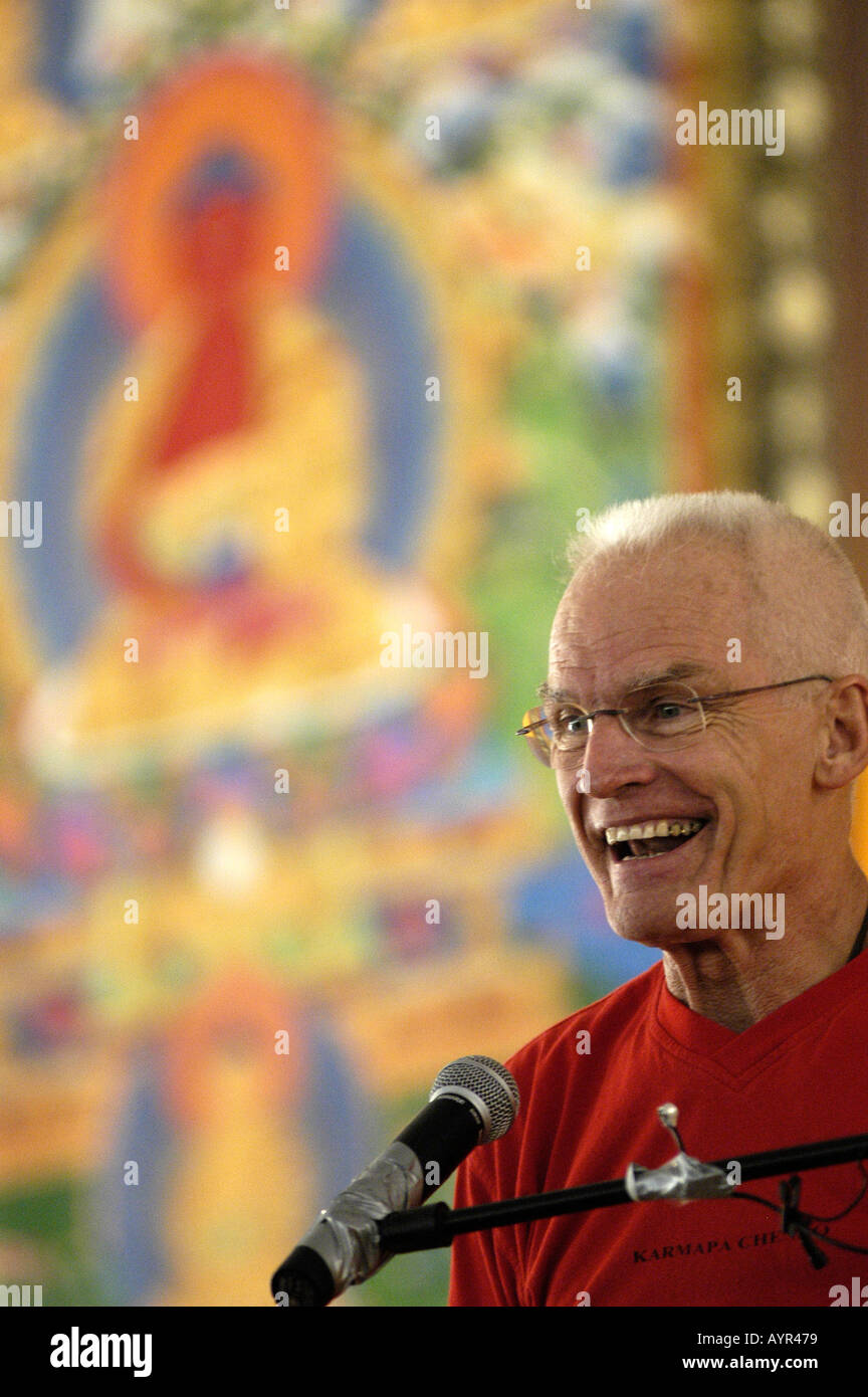Lama Ole Nydahl smiling In background large tibetan buddhist thangka of ...