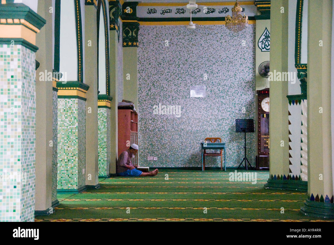 Muslim man sitting in prayer hall reading Masjid Abdul Gafoor Mosque ...
