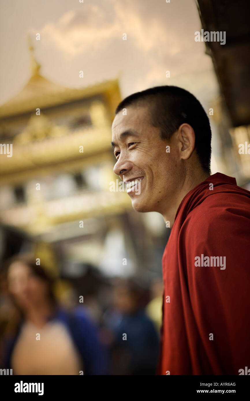 Close up profile portrait of a smiling Tibetan monk in a village street ...