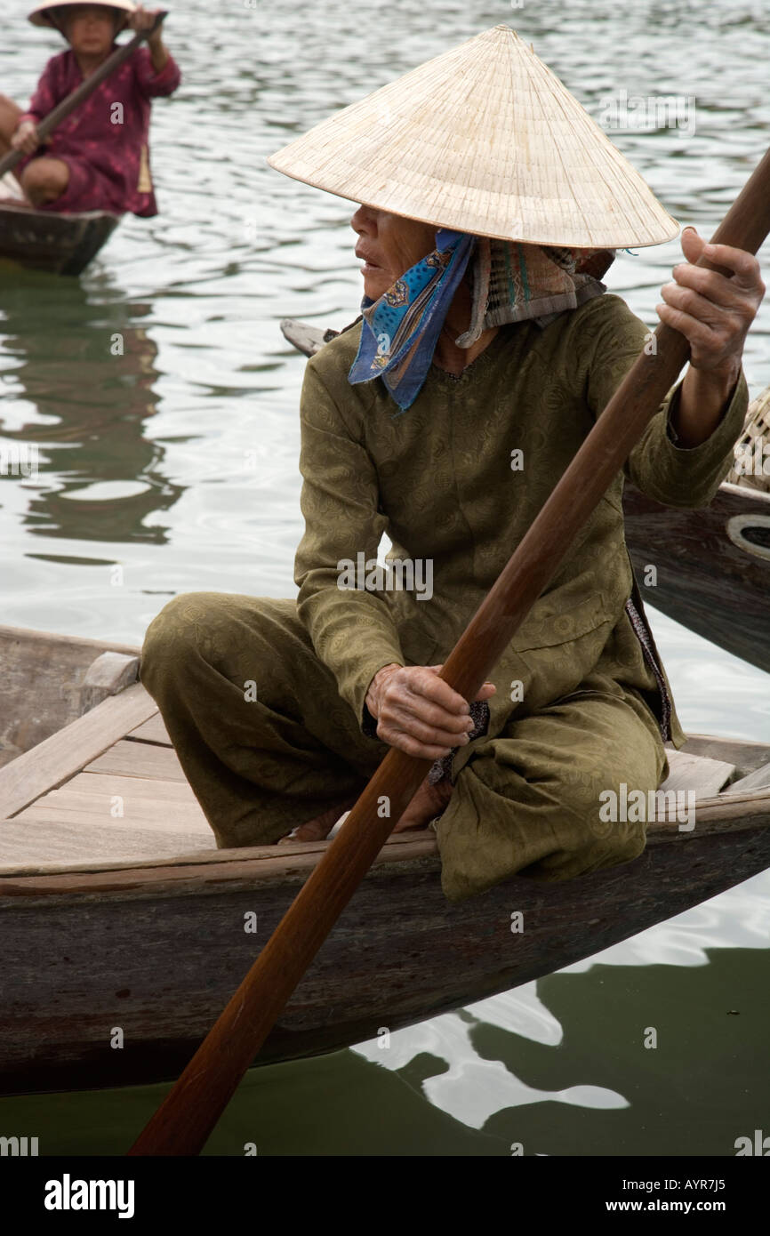 Vietnamese woman in conical hat poles her wooden boat, Hoi An, Vietnam ...