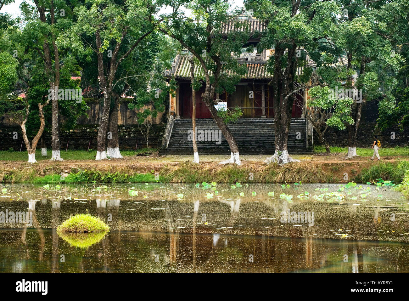 Temple ruin under restoration, with pond and walking tourist, Hue ...