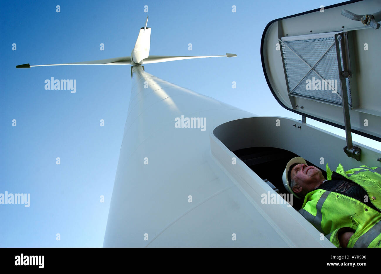 a builder stands inside the door at the base of a new wind turbine ...
