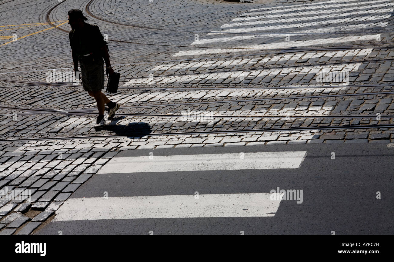 Man walking across a Zebra crossing in Prague Stock Photo - Alamy