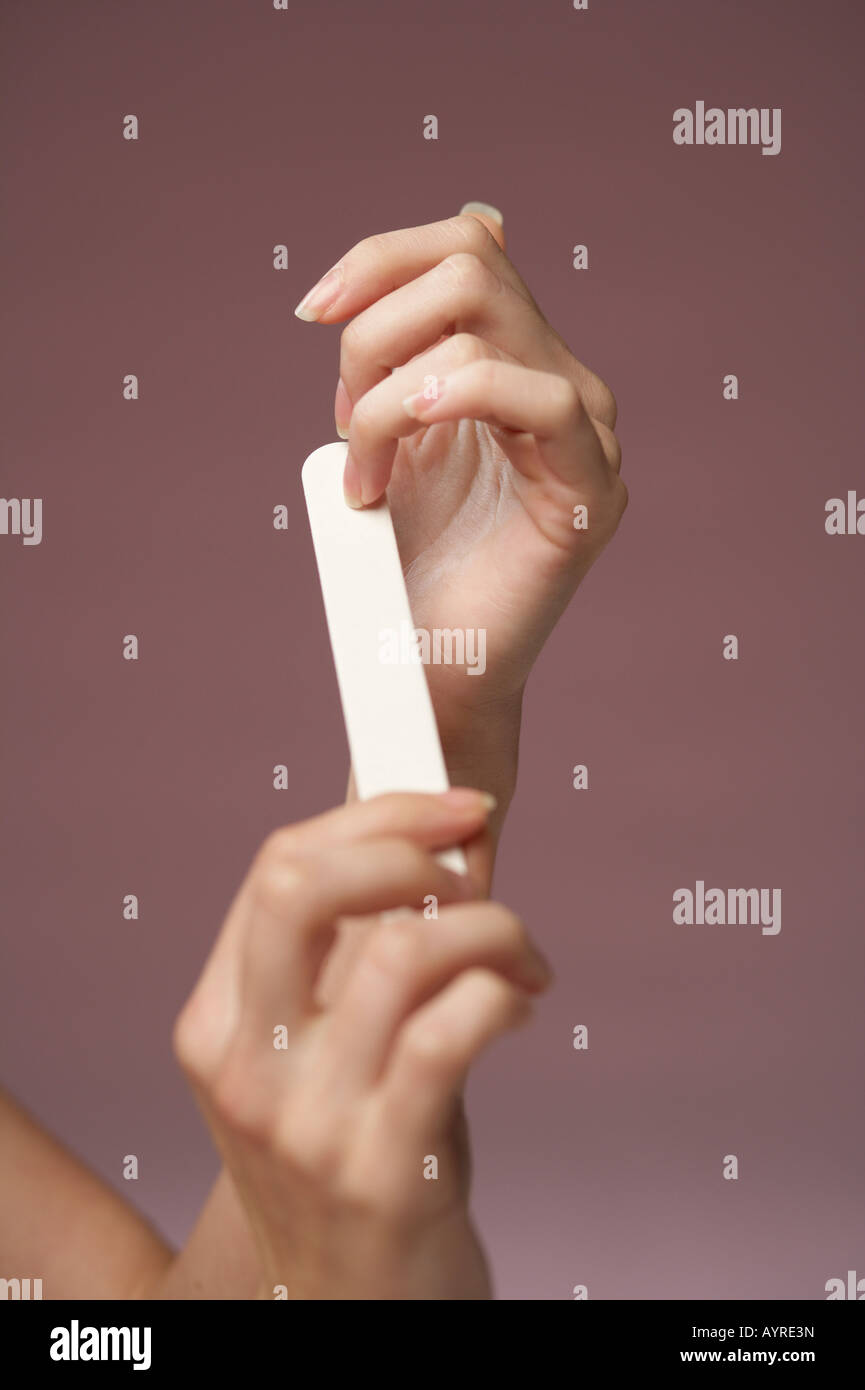 Young woman filing nails Stock Photo - Alamy