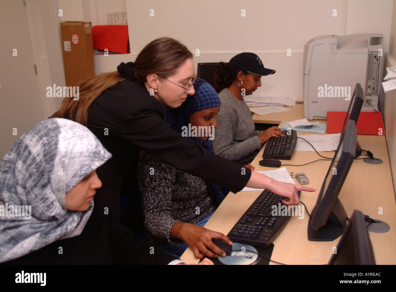 Group of ethnic women in adult education class learning computer skills ...