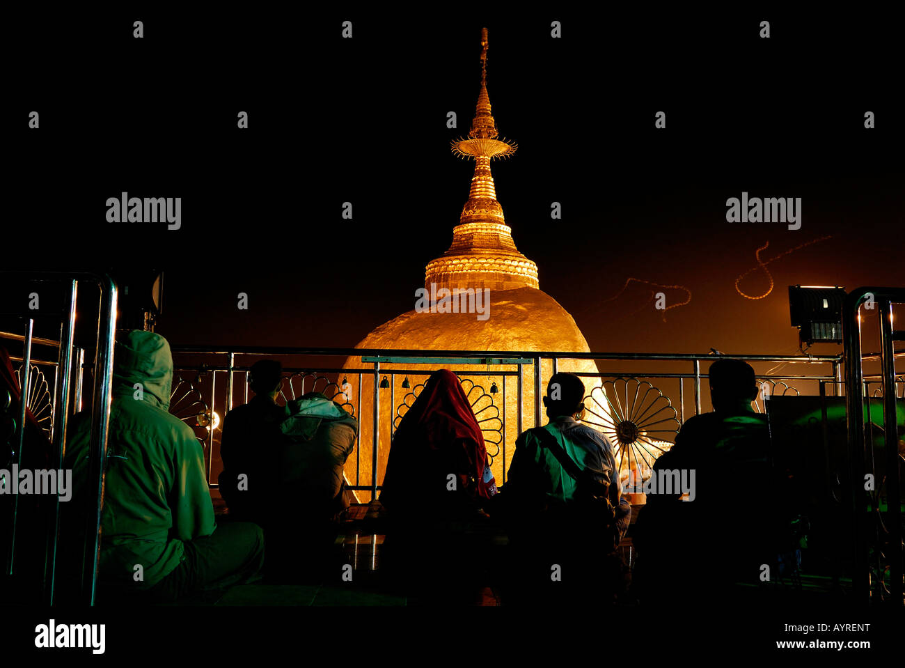 People praying in front of a golden rock and stupa, Kyaikhtiyo, Myanmar ...