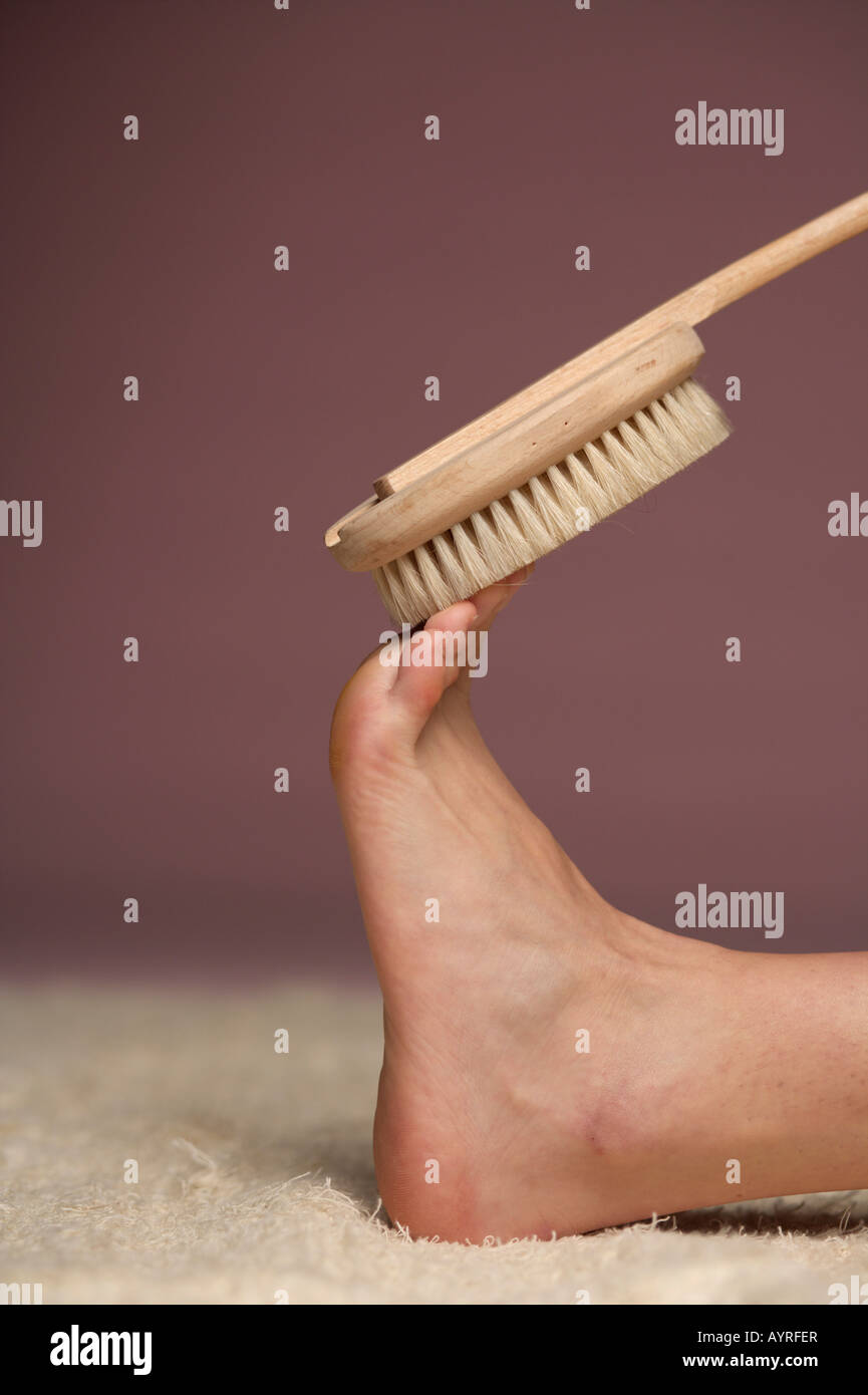 Female foot balancing brush Stock Photo - Alamy
