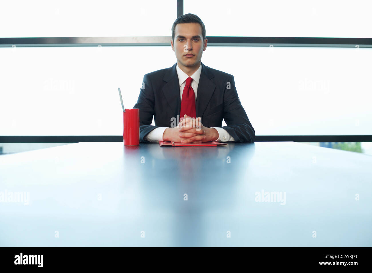Businessman sitting at a table, portrait Stock Photo - Alamy