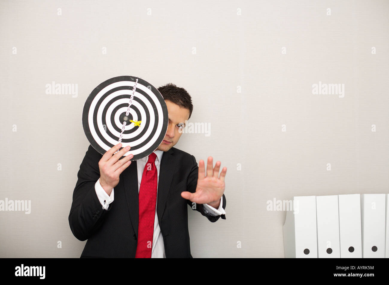 Businessman covering face with a dartboard Stock Photo - Alamy