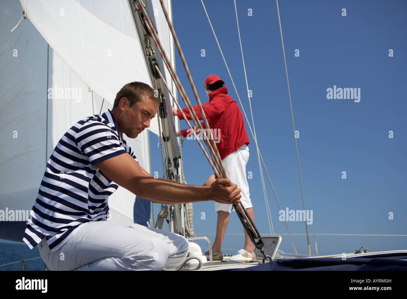 Two men working on a sailing yacht Stock Photo - Alamy