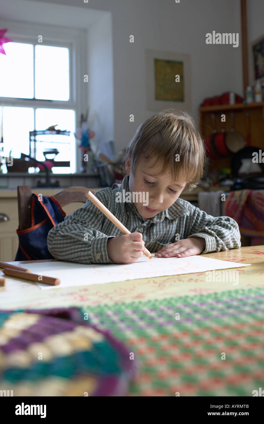 Boy drawing at table Stock Photo - Alamy