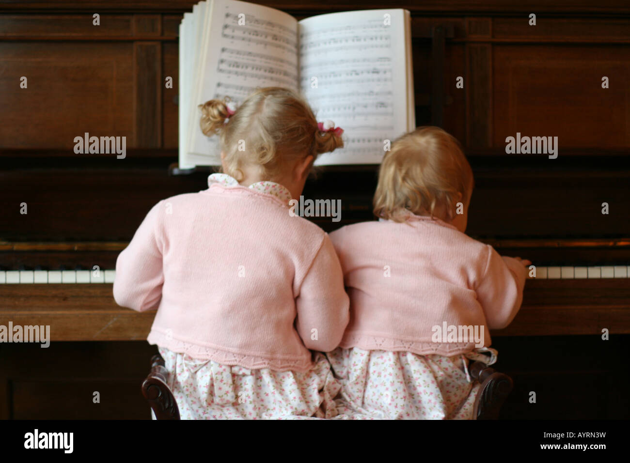 Two young girls playing the piano, UK Stock Photo - Alamy