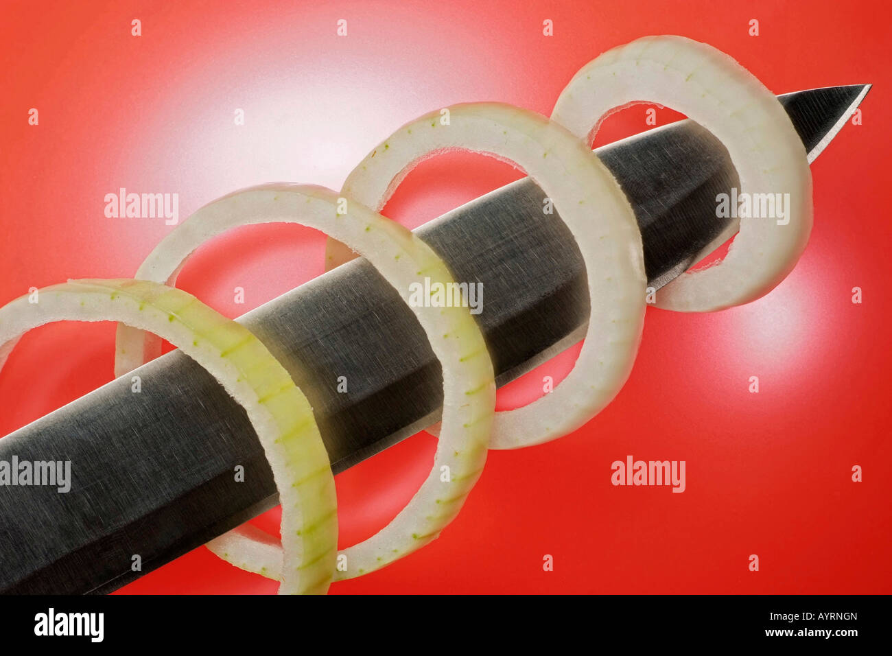 Knife holding raw onion rings Stock Photo - Alamy