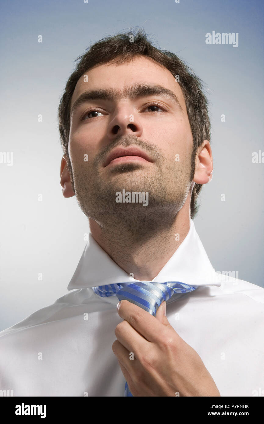 Man tightening his tie Stock Photo - Alamy