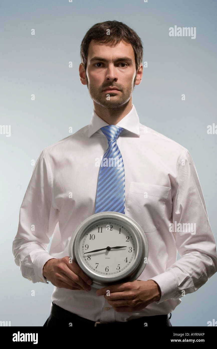 Businessman holding clock Stock Photo - Alamy