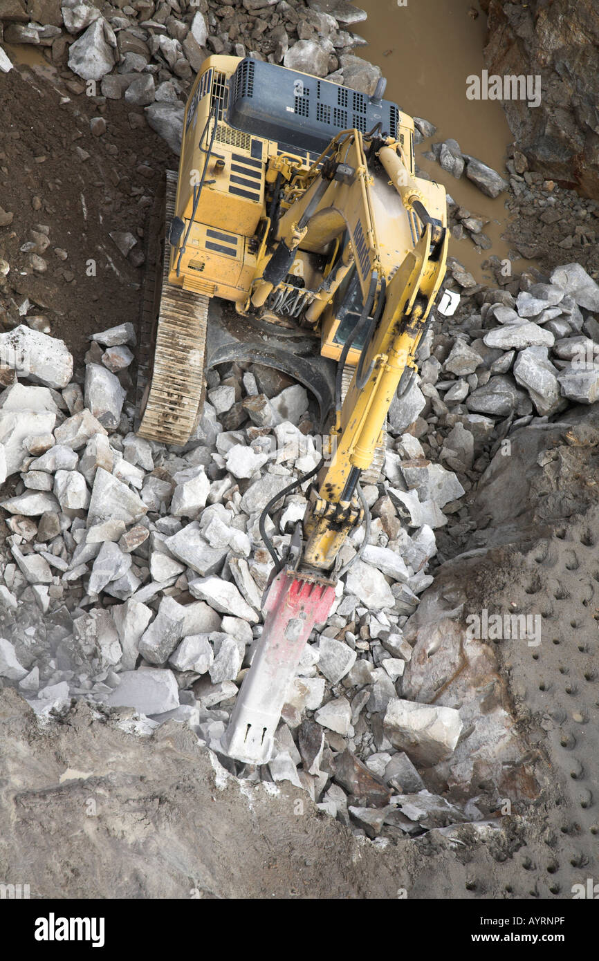 Large machine breaking the ground on a construction site viewed from ...