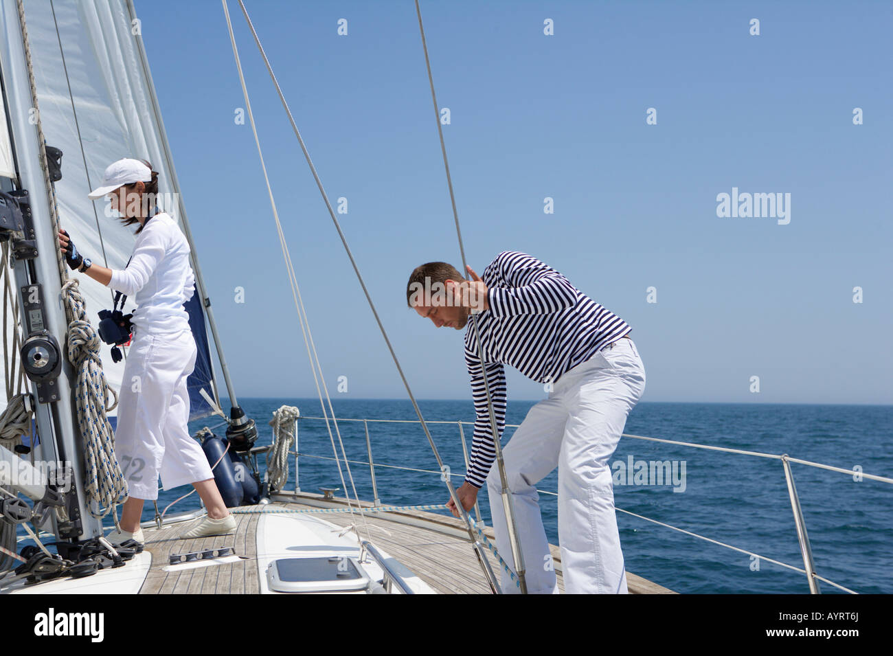 Two people working on a sailing boat Stock Photo - Alamy