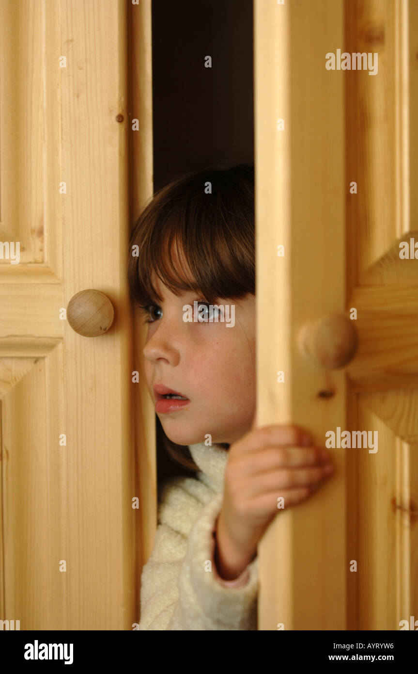 Girl peeping out of a cupboard door Stock Photo - Alamy