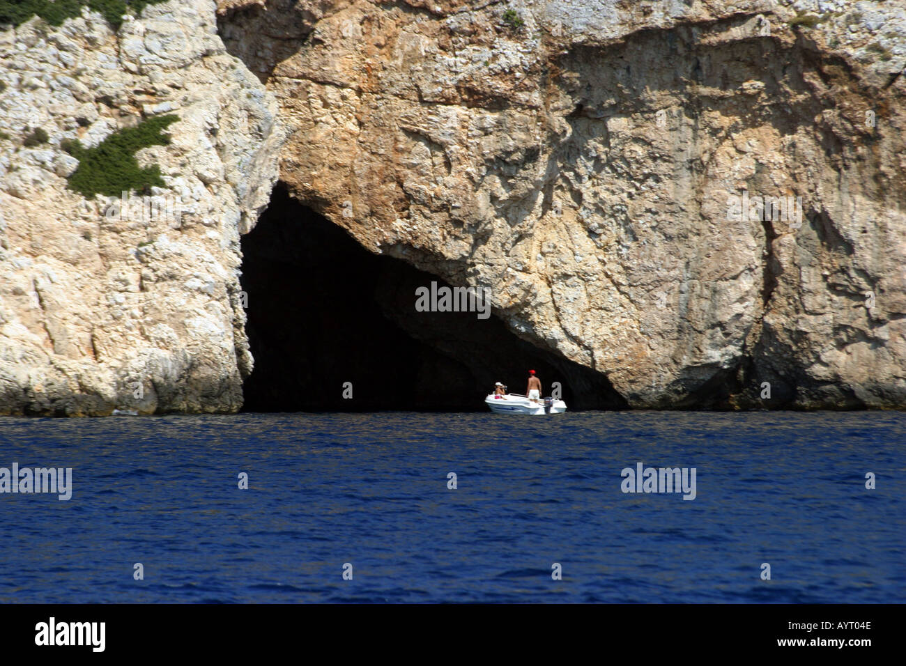 A little boat is aproaching the Blue Cave at Gioura island Alonisos ...
