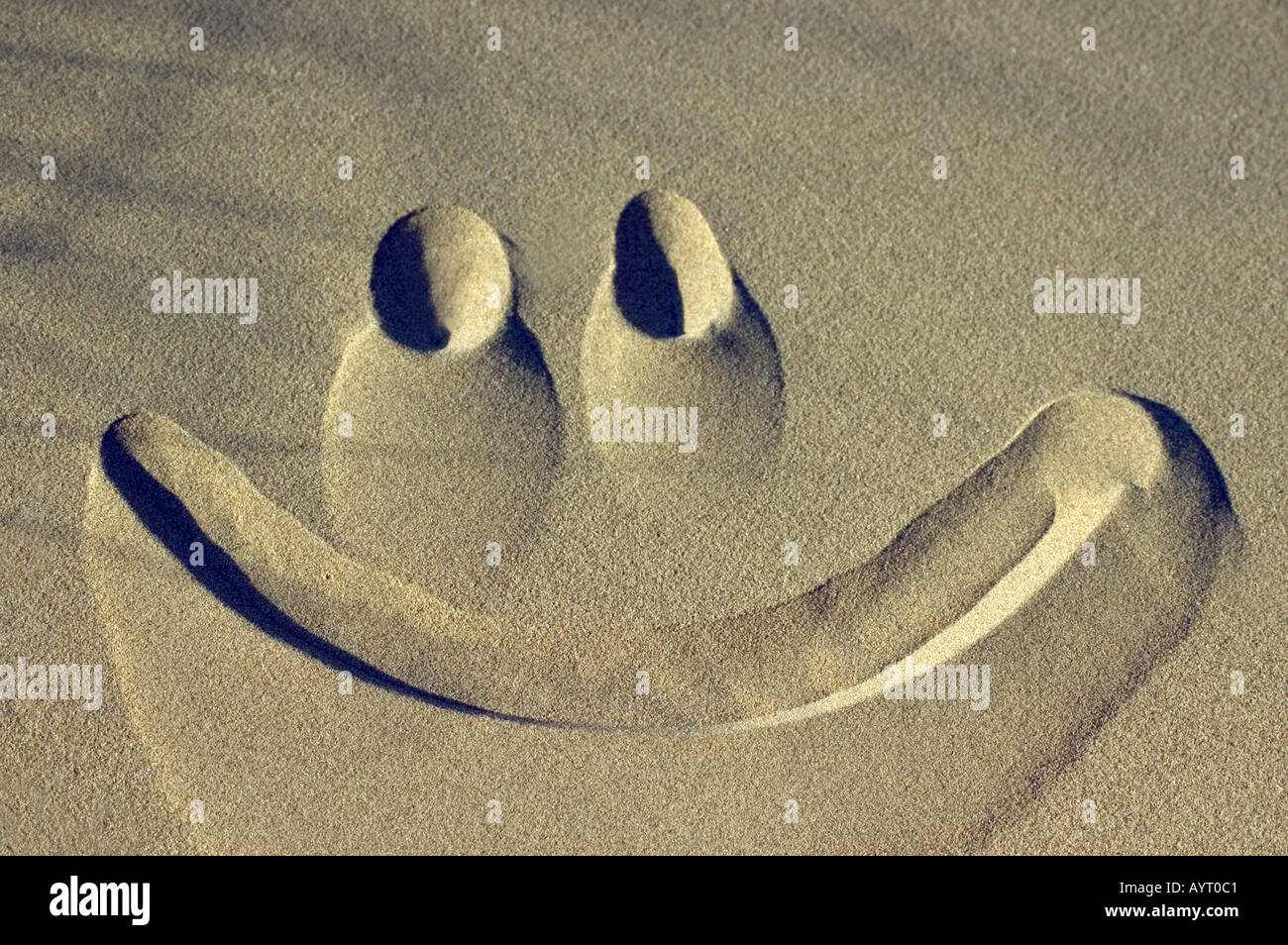 Smiling Face drawn in sand Stock Photo - Alamy