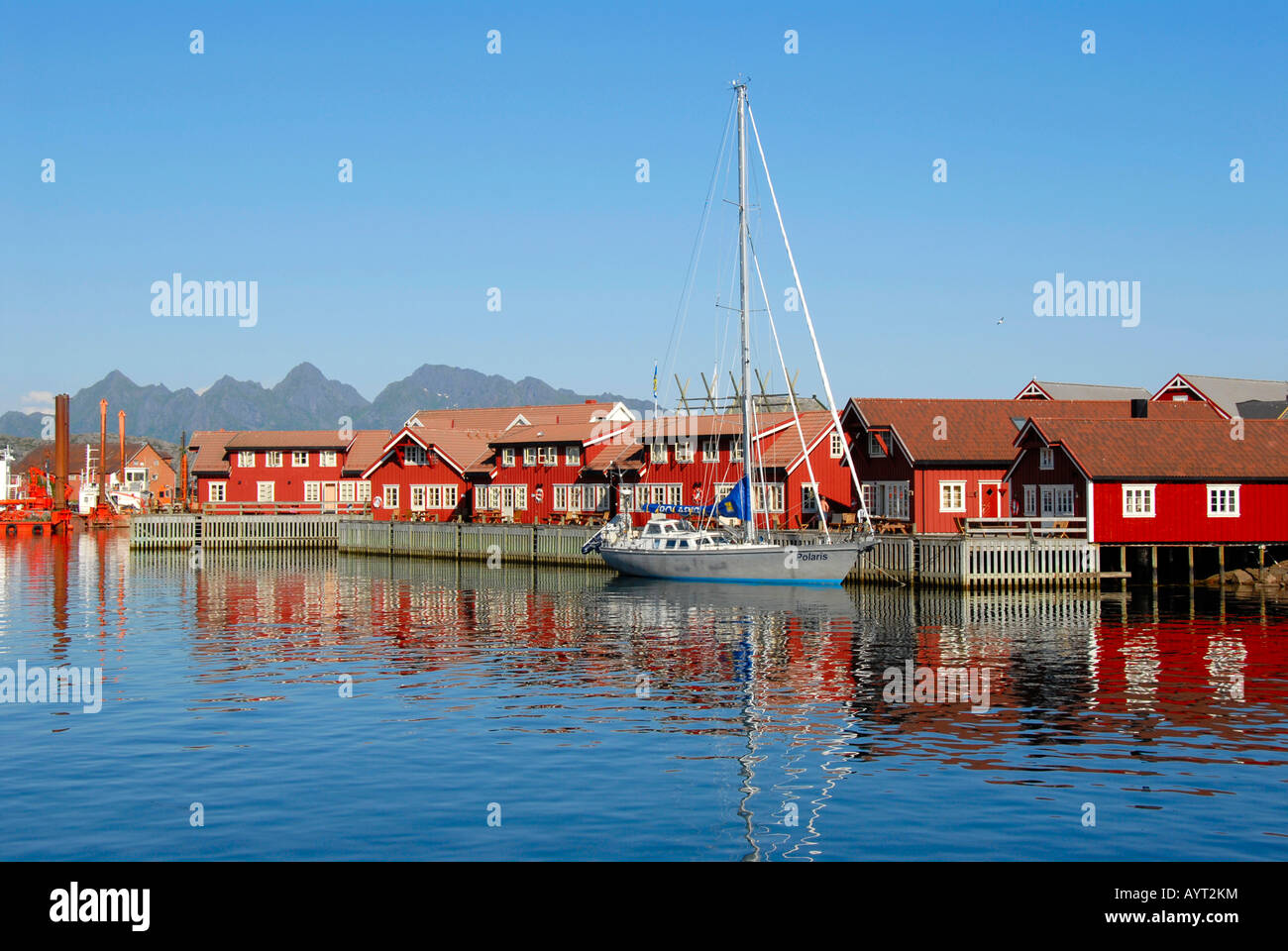 Red Rorbuer houses, fishing village reflected on the smooth surface ...