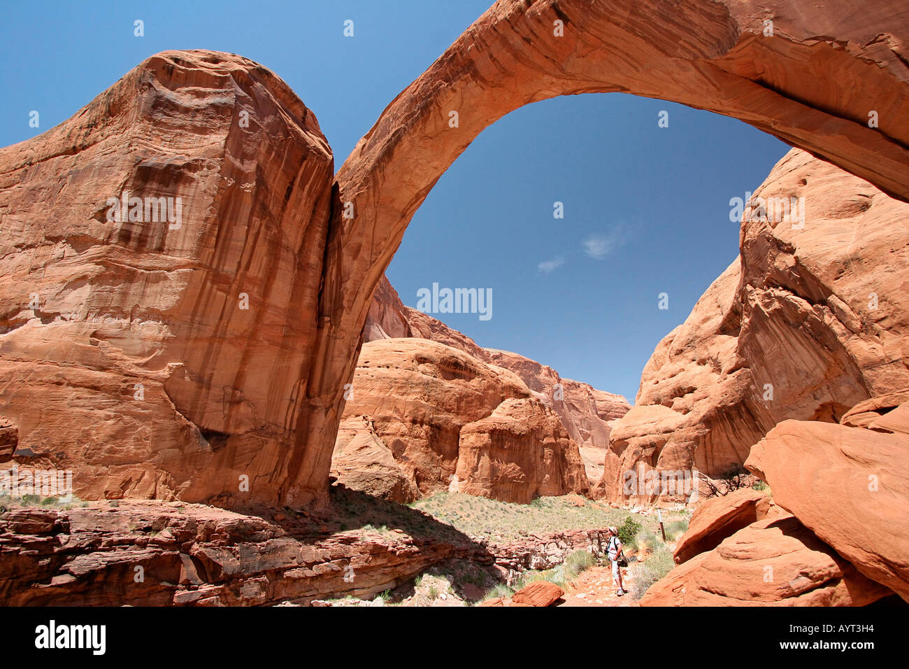 Visitor looking at arch of Rainbow Bridge National Monument Stock Photo ...