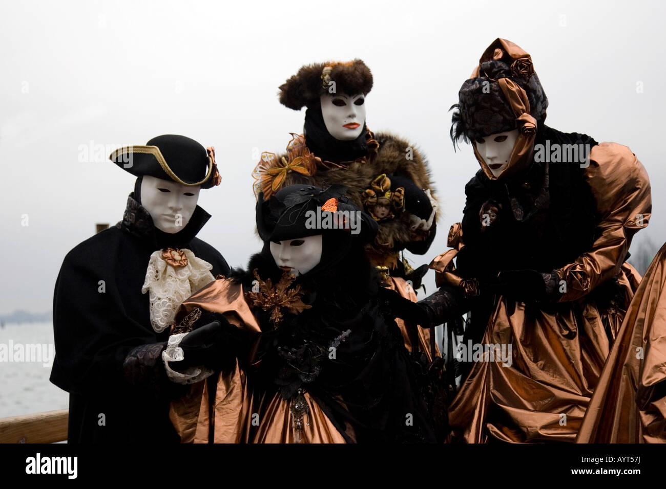 Four black and brown costumes with masks, Carnevale di Venezia ...