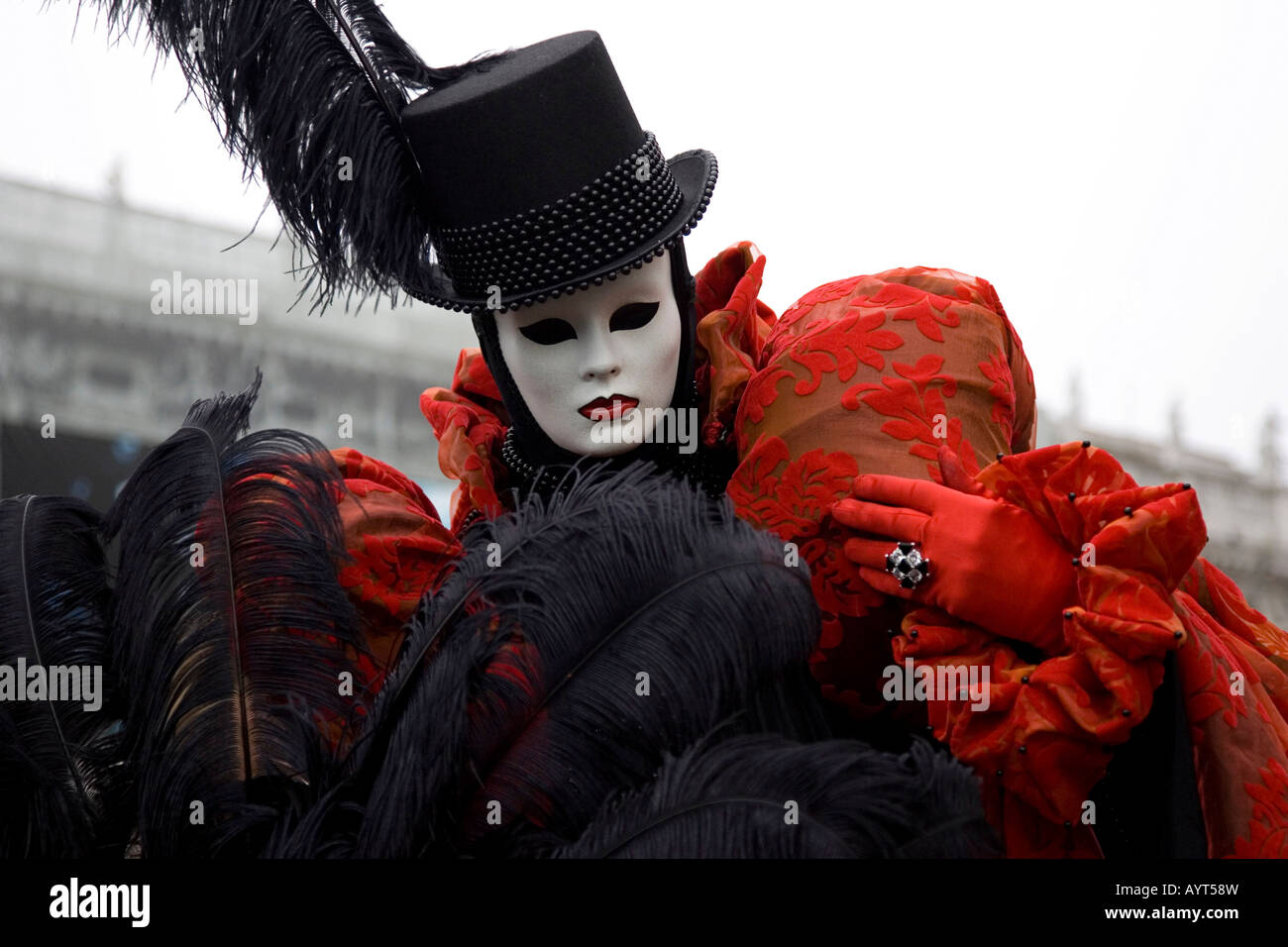Colourful red-and-black costume and large top hat, mask and feathers ...