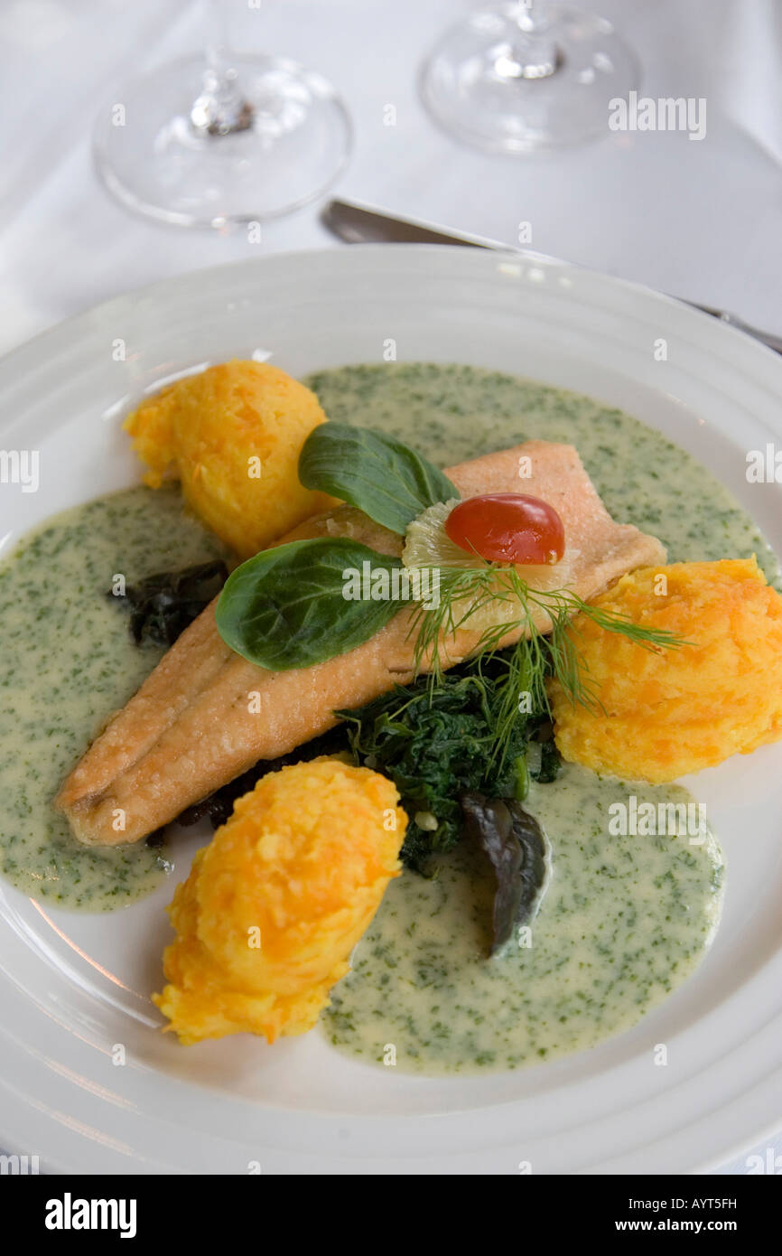 Fresh fish filet served with scalloped potatoes, spinach and herb cream ...