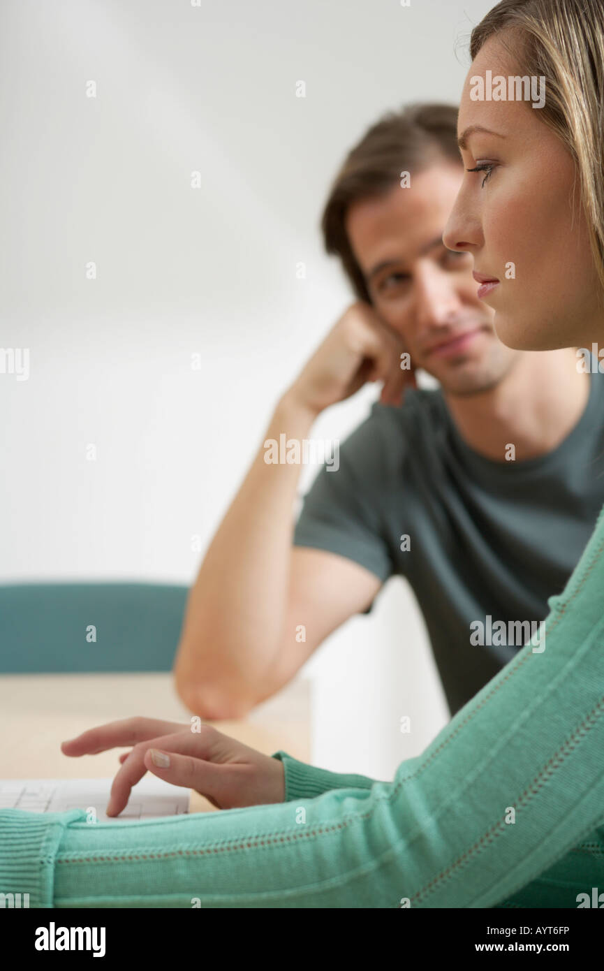 Man watching woman working Stock Photo - Alamy