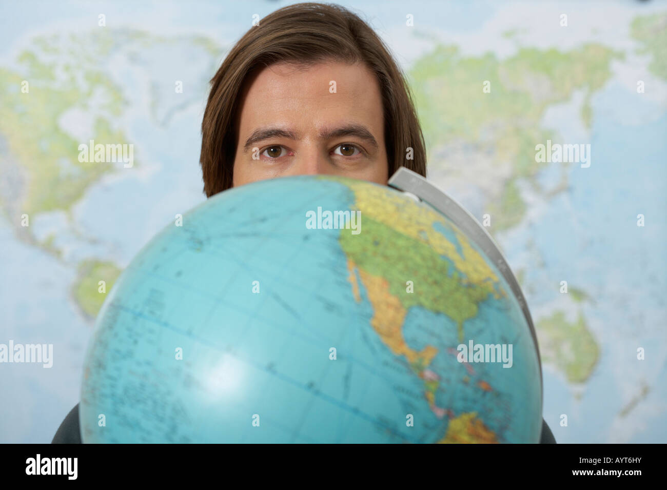 A man in the middle of world map and globe Stock Photo - Alamy