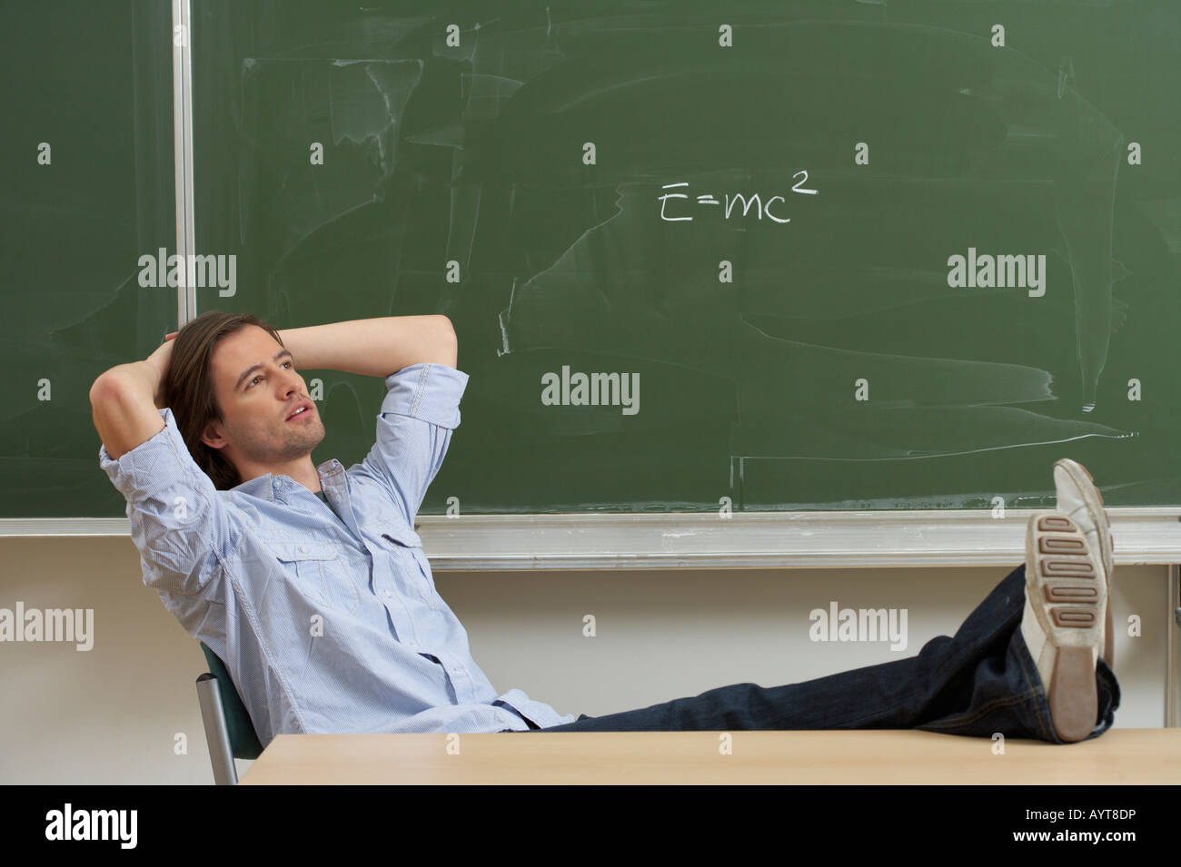 A man is sitting on the chair and the feed lying on the table Stock ...