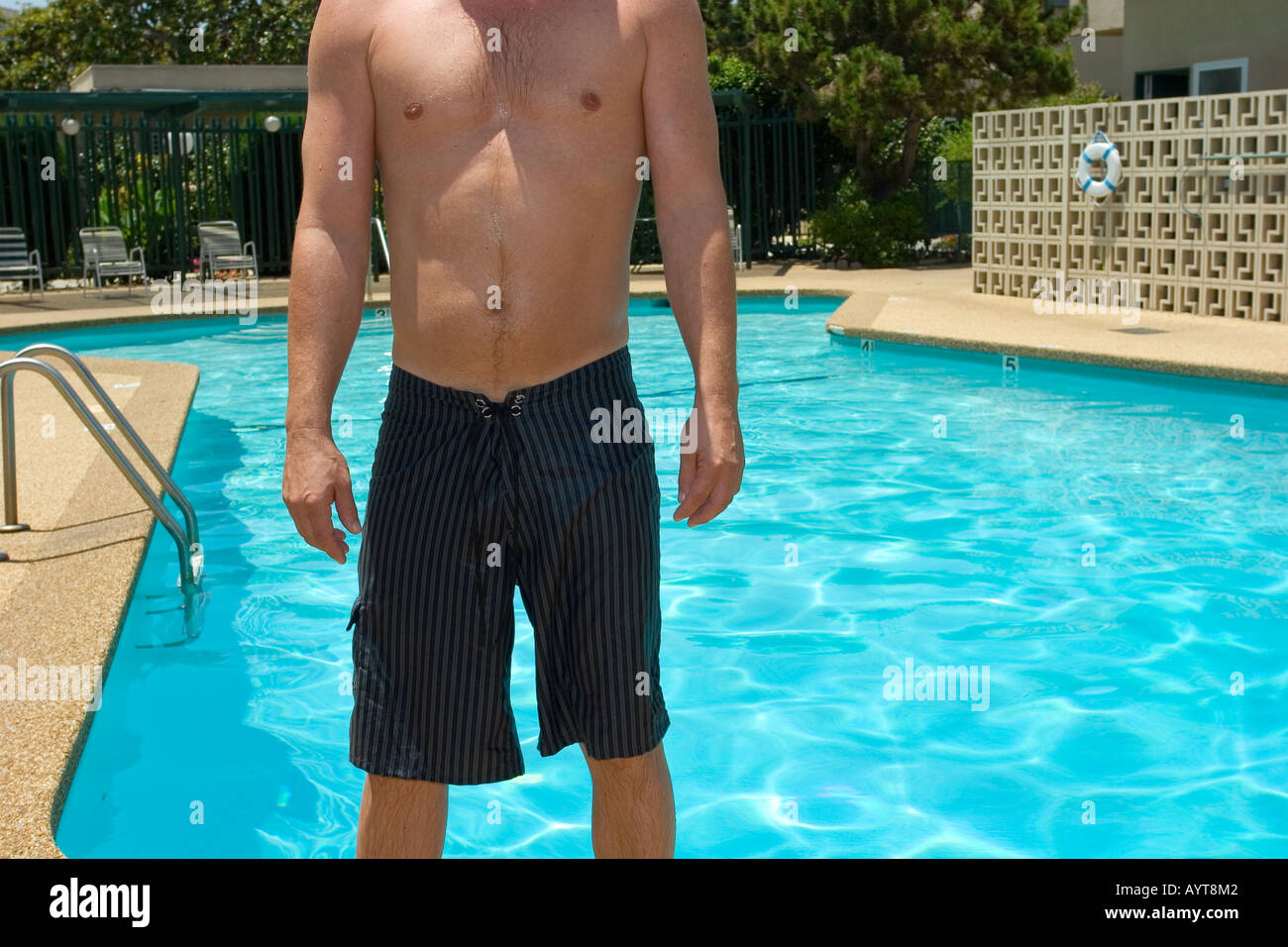 torso of man standing by swimming pool Stock Photo - Alamy