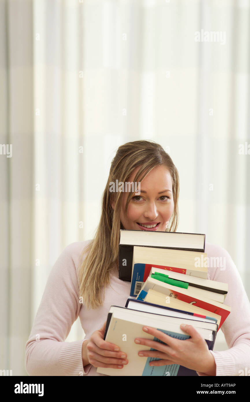 A woman is carrying some books Stock Photo - Alamy
