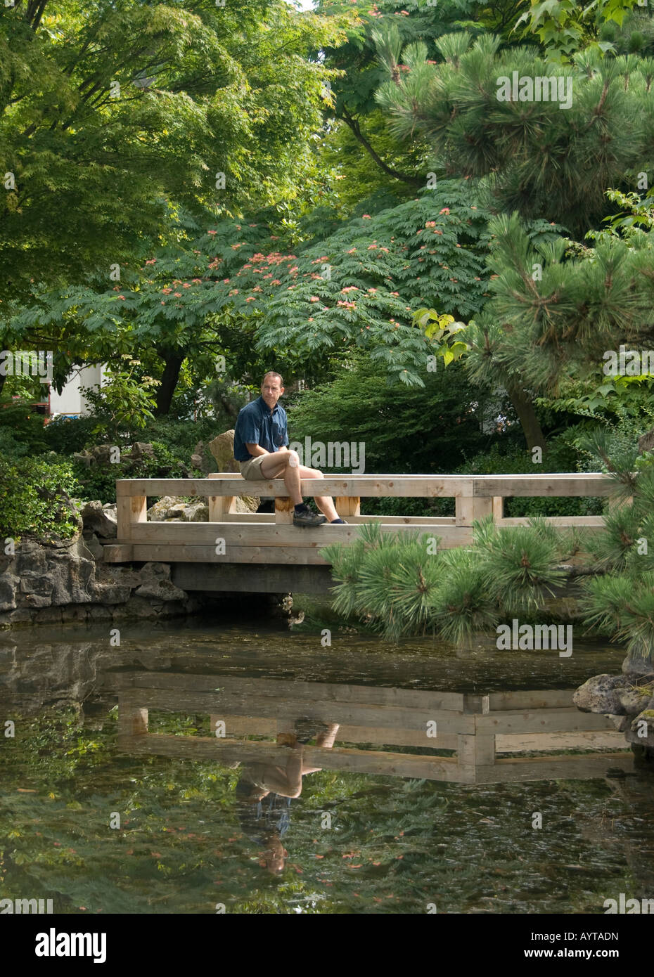 A lone man sits and contemplates in a Chinese garden Stock Photo - Alamy