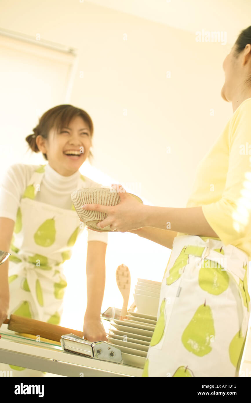 Two women laughing in the kitchen Stock Photo - Alamy