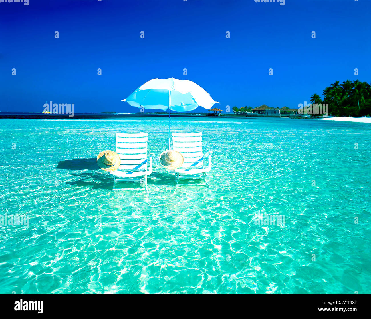 Two lounge chairs in the beach water Stock Photo - Alamy