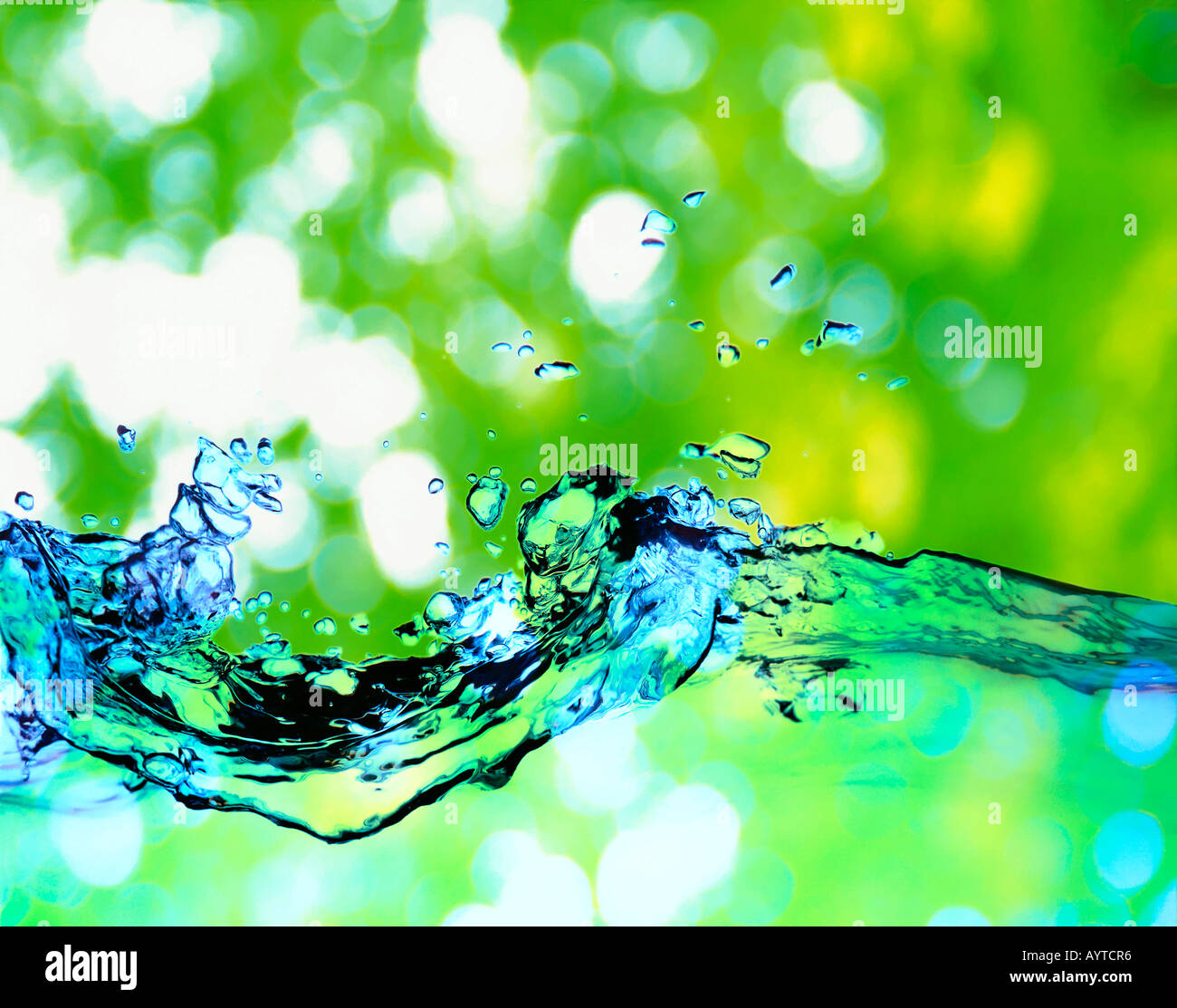 Splashing clear water in front of green background Stock Photo - Alamy
