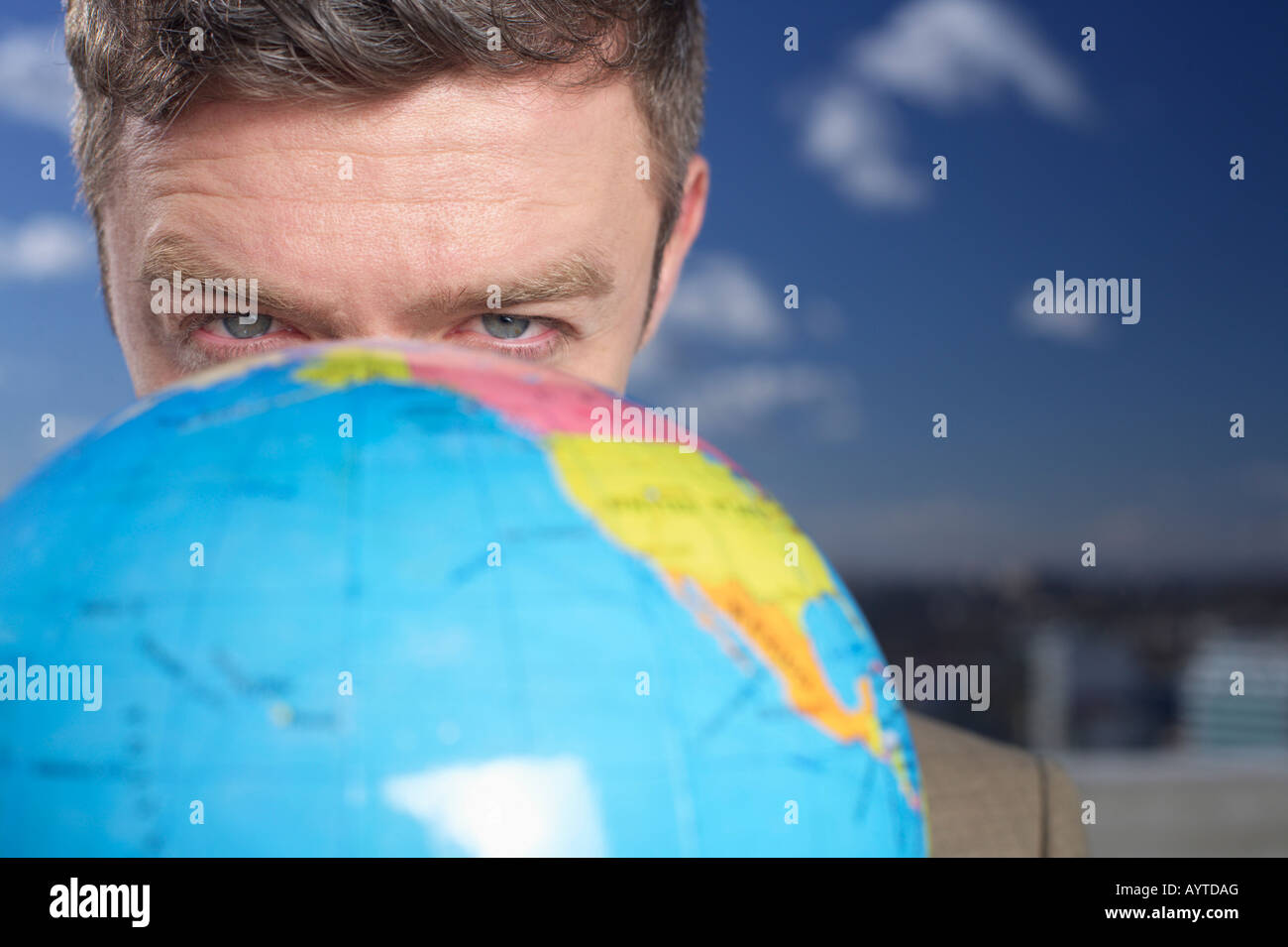 Businessman looking over a globe at camera Stock Photo - Alamy