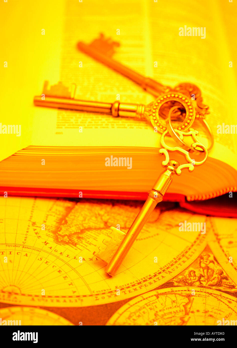 Three gold keys stacked on top of an open book on a world map Stock ...