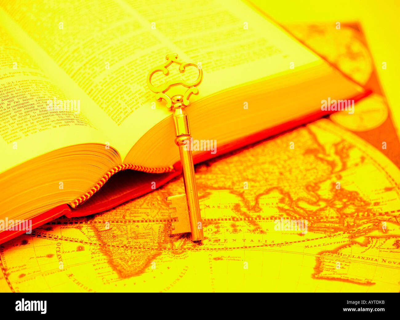 One gold key on top of an open book and a world map Stock Photo - Alamy