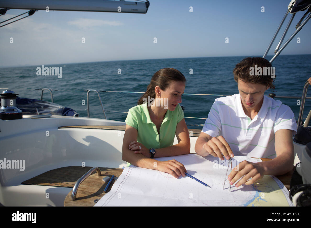 Two people working on a sea chart Stock Photo - Alamy