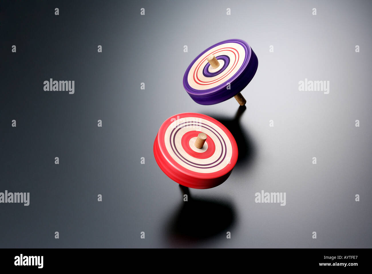 Two spinning tops spinning with a black background Stock Photo - Alamy